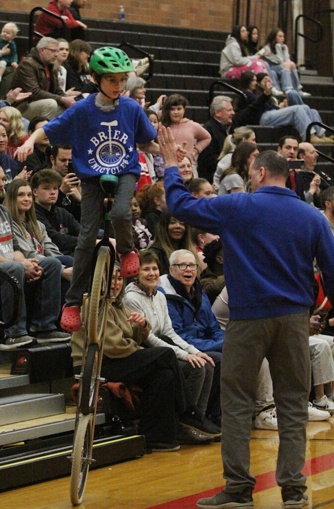 Heck on wheels: Unicycle riders entertain crowd at basketball half-time ...