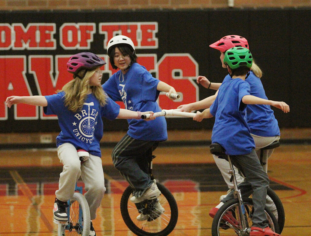 Heck on wheels: Unicycle riders entertain crowd at basketball half-time ...
